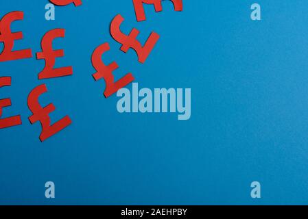 Paper yellow symbols of british pound currency on blue background. View ...