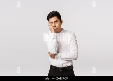 Sad and bored man lean face on hand, looking at camera empty-headed ...