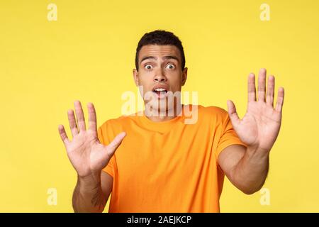 Guy panicking, feeling anxious and scared clenching teeth holding hands ...