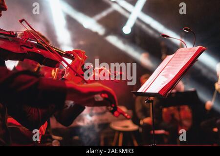 Red colored violin concert at bright rock stage Stock Photo - Alamy