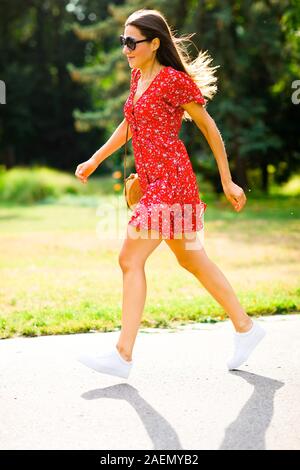 Woman in red dress running away Stock Photo - Alamy