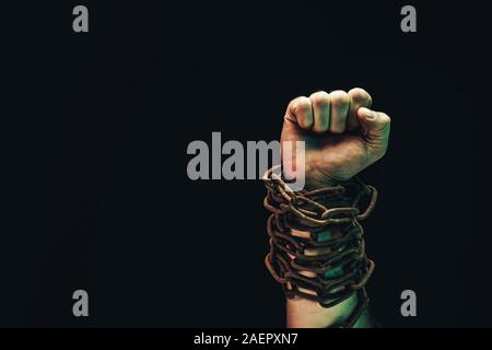 Fist of Hand are chained in chains on the black background, concept of ...