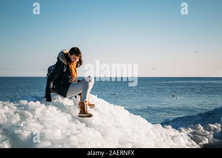 frozen ice blocks on sea beach in winter with sand and snow in overcast ...
