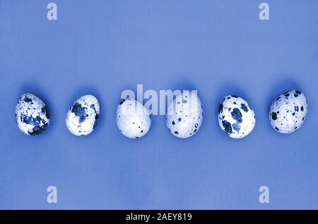 Quail eggs on phantom classic blue color tone surface, top view, empty ...
