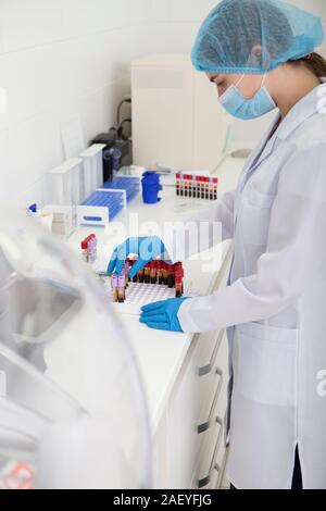 Woman sorting test tubes in a laboratory Stock Photo - Alamy