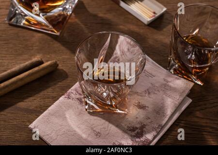 Brandy with map, cigars and matches on wooden table, panoramic shot ...