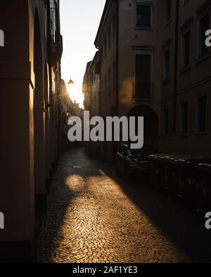Cobblestone paved square under a historic building with a tower in an ...