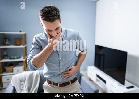 Young man suffering from nausea over sink in bathroom Stock Photo - Alamy