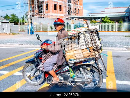 Man carrying cage loaded with dogs on moped Hoi Chi Minh City formerly ...