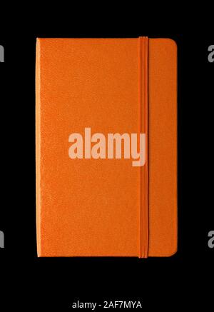Orange closed notebook mockup isolated on dark concrete background ...