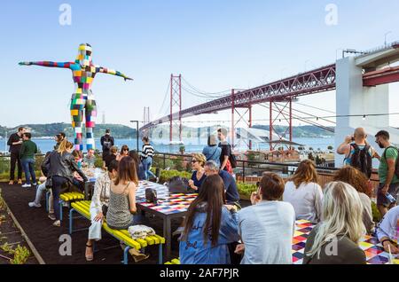 Rooftop bar with statue at LX Factory, under the Ponte 25 de Abril ...