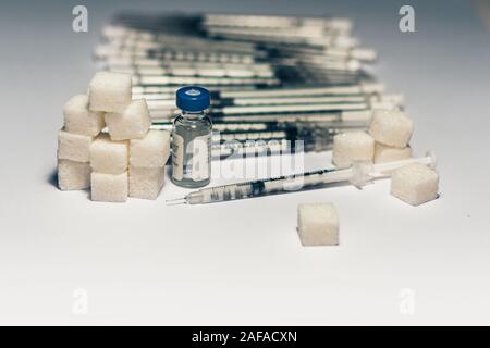 Sugar cubes with syringes for insulin injection on blue background ...