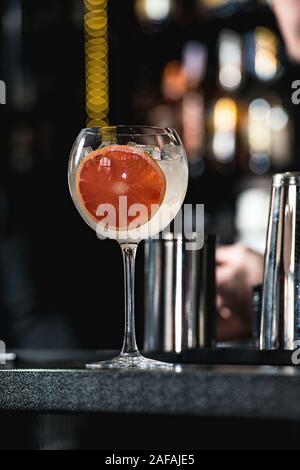 refreshing ruby red coctail with grape fruit isolated on a bar ...