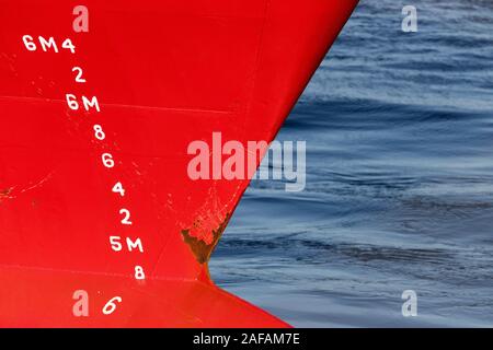 Draft marks on red bow of large ship Stock Photo - Alamy