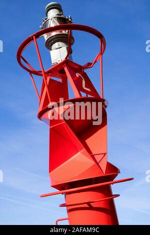 Red maritime navigation buoy floating in turquoise ocean waters near a ...