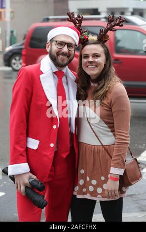 People dressed as Santa Claus and elves walked through the city, giving ...
