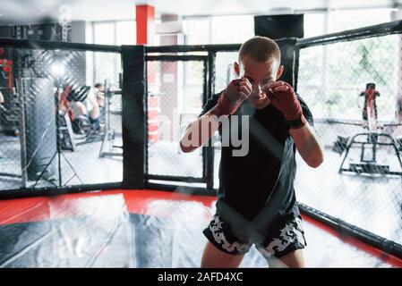 young male fighter wear bandages on fist. muscular man bind bandage on ...