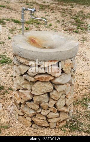 Medieval stone sink with fresh clean water in an old autumn garden in ...