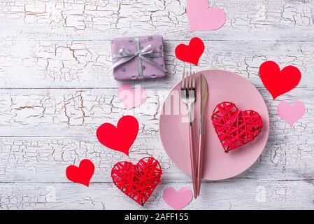 Table setting for Valentine's Day with hearts on pink background Stock ...