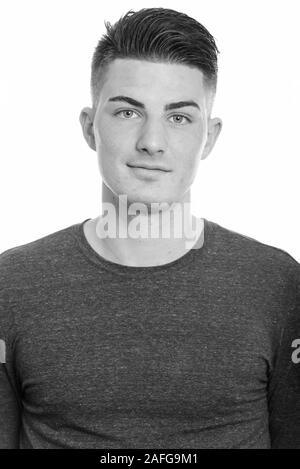 Young handsome man in black T-shirt on colour textured wall background ...