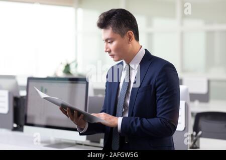 Successful businessman reading file in office Stock Photo - Alamy