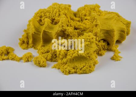 yellow kinetic sand scattered on a white table Stock Photo - Alamy