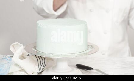 Frosting round three-layer vanilla cake with buttercream frosting Stock ...