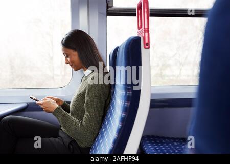 Woman use of mobile phone inside train compartment Stock Photo - Alamy