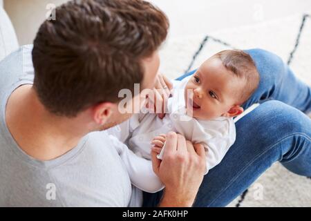 African man plays with his lying on bed mixed race baby daughter. Baby ...