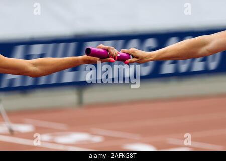 woman athletic runners passing baton in relay race Stock Photo - Alamy