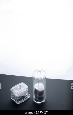 ear sticks in glass, cosmetic cream and toothbrush near bamboo stem in ...