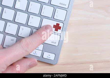 A finger presses a button with a heart sign on the keyboard. Close up ...