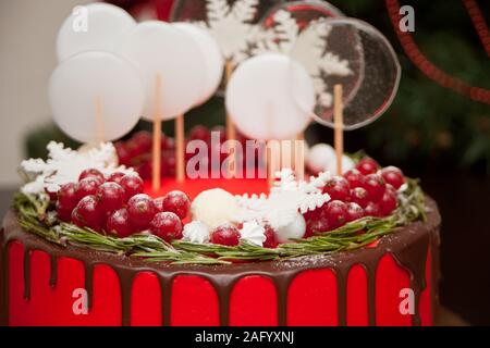 Christmas red cake with chocolate smudges, decorated red currant, candy ...