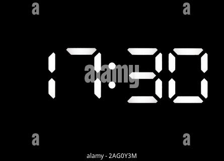 Real white led digital clock on a black background showing time 5:01 ...
