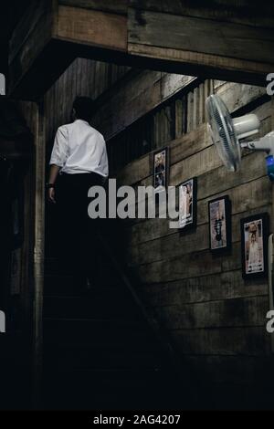 A vertical shot of a guy going up on an escalator inside a building ...