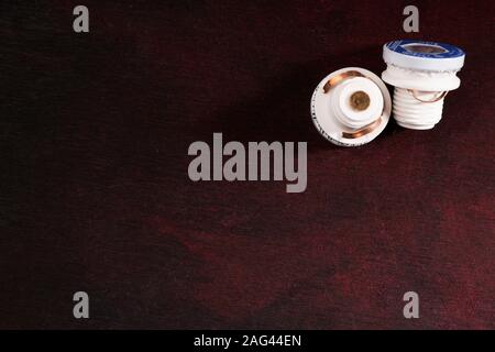 Electrical screw-in fuses on dark red-black background with copy space ...
