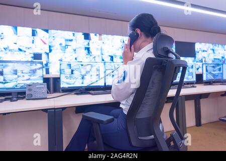 Female security guard operator talking on the phone, calling in the ...