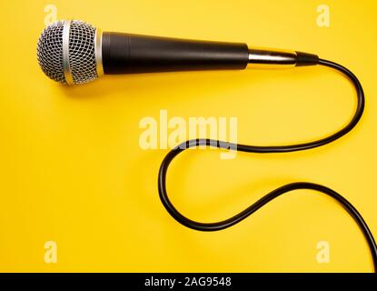 Microphone with curly cable on yellow background Stock Photo - Alamy