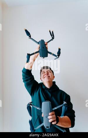Guy holds two quadrocopters against a wall Stock Photo - Alamy