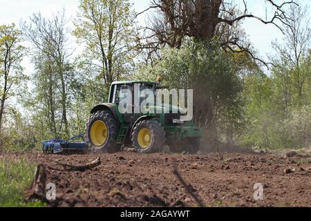 LATVIA, TUKUMS - 30 APRIL: Tractor work on the field in a springtime ...
