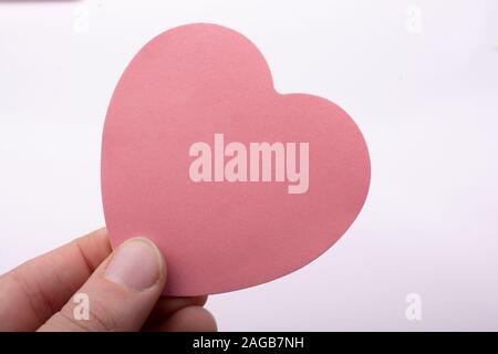 Pink color heart shaped paper in hand as love concept Stock Photo - Alamy