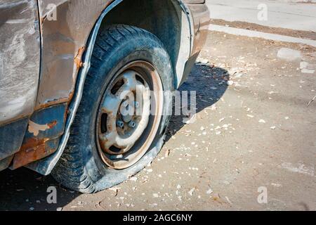 Deflated damaged tyre detail of an white car Stock Photo - Alamy