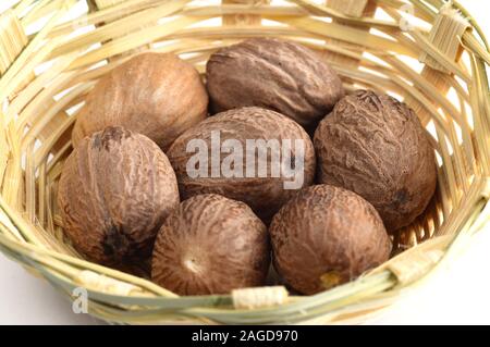 Nutmeg in bamboo basket isolated on white background Stock Photo - Alamy
