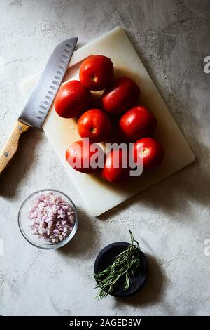 A Vertical shot of a chef slicing tomatoes on a wooden board Stock ...