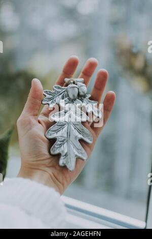 Vertical shot of a person holding a Christmas tree lights in its palm ...