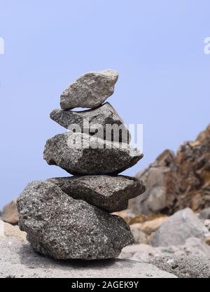 A vertical shot of a stack of balancing rocks in the water - zen ...