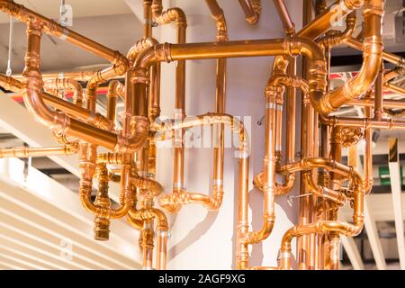 Copper pipes in an intricate formation against a white wall Stock Photo ...
