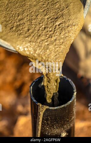Construction worker applying cement mixture with trowel on tile surface ...