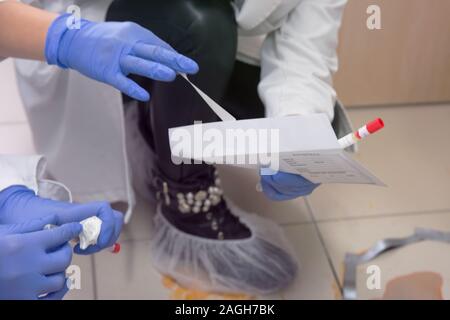 Forensic technicians taking DNA sample from blood stain with cotton ...