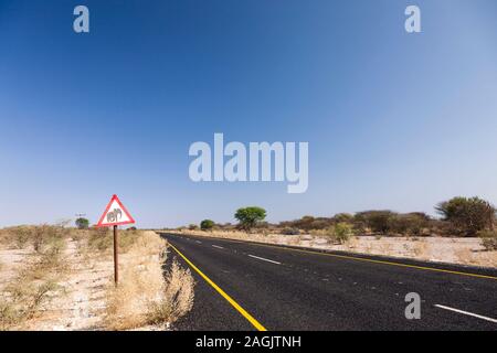 Long tar road with animal sign, in Kalahari desert near Rakops, Central ...